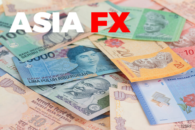 Asian currencies edge lower as dollar shows resilience